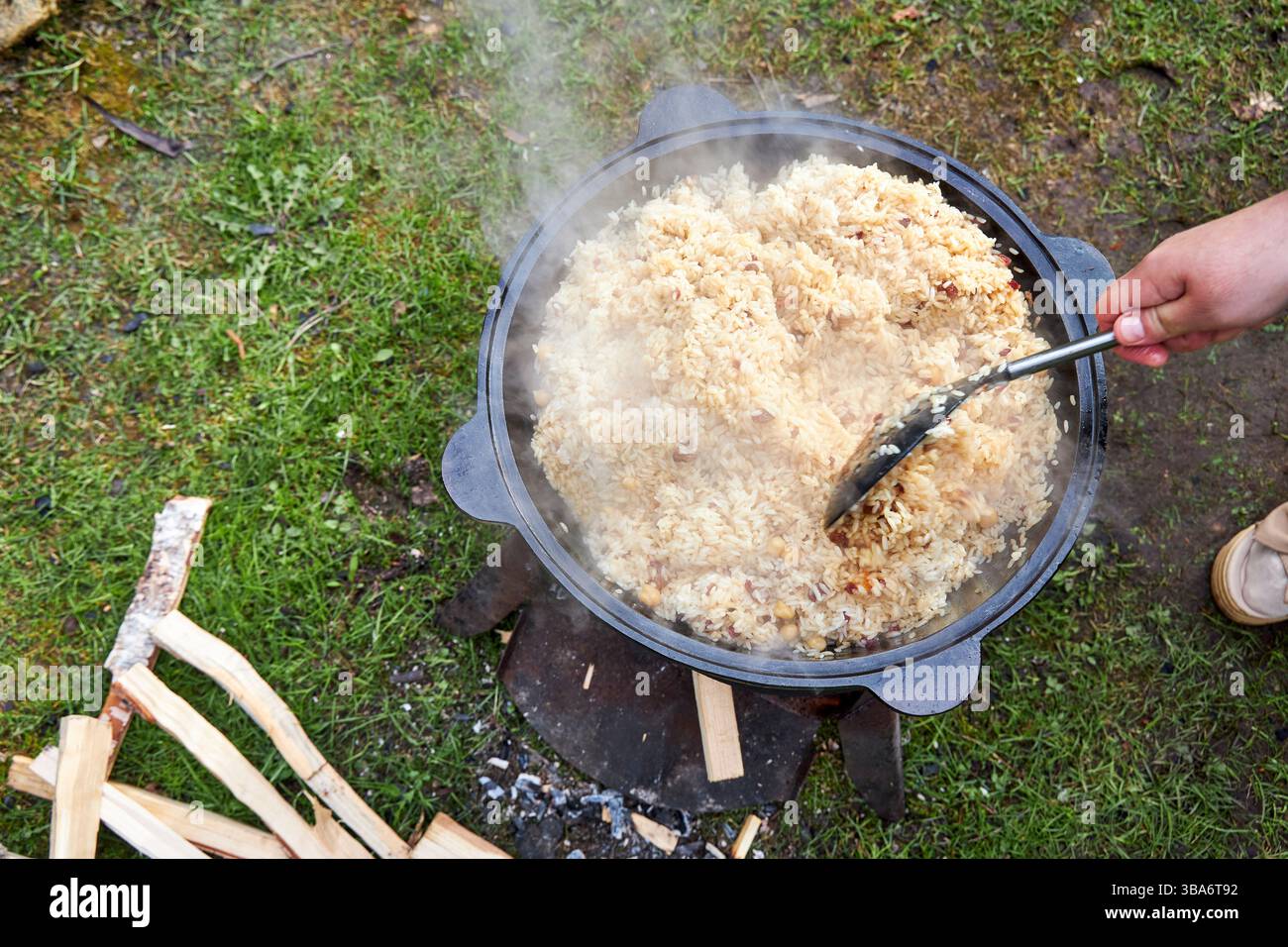 Top view of the cooking process of pilaf over an open fire in a ...