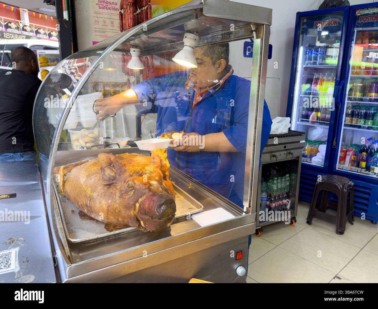 A fast food booth on the street selling meat from a roasted pig in ...