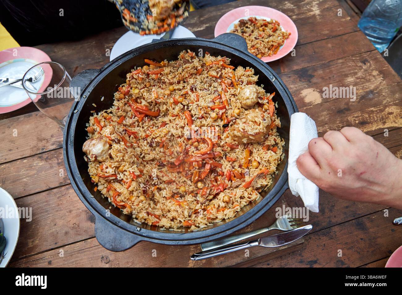 Top view of ready-made oriental pilaf in a black cauldron placed on an ...