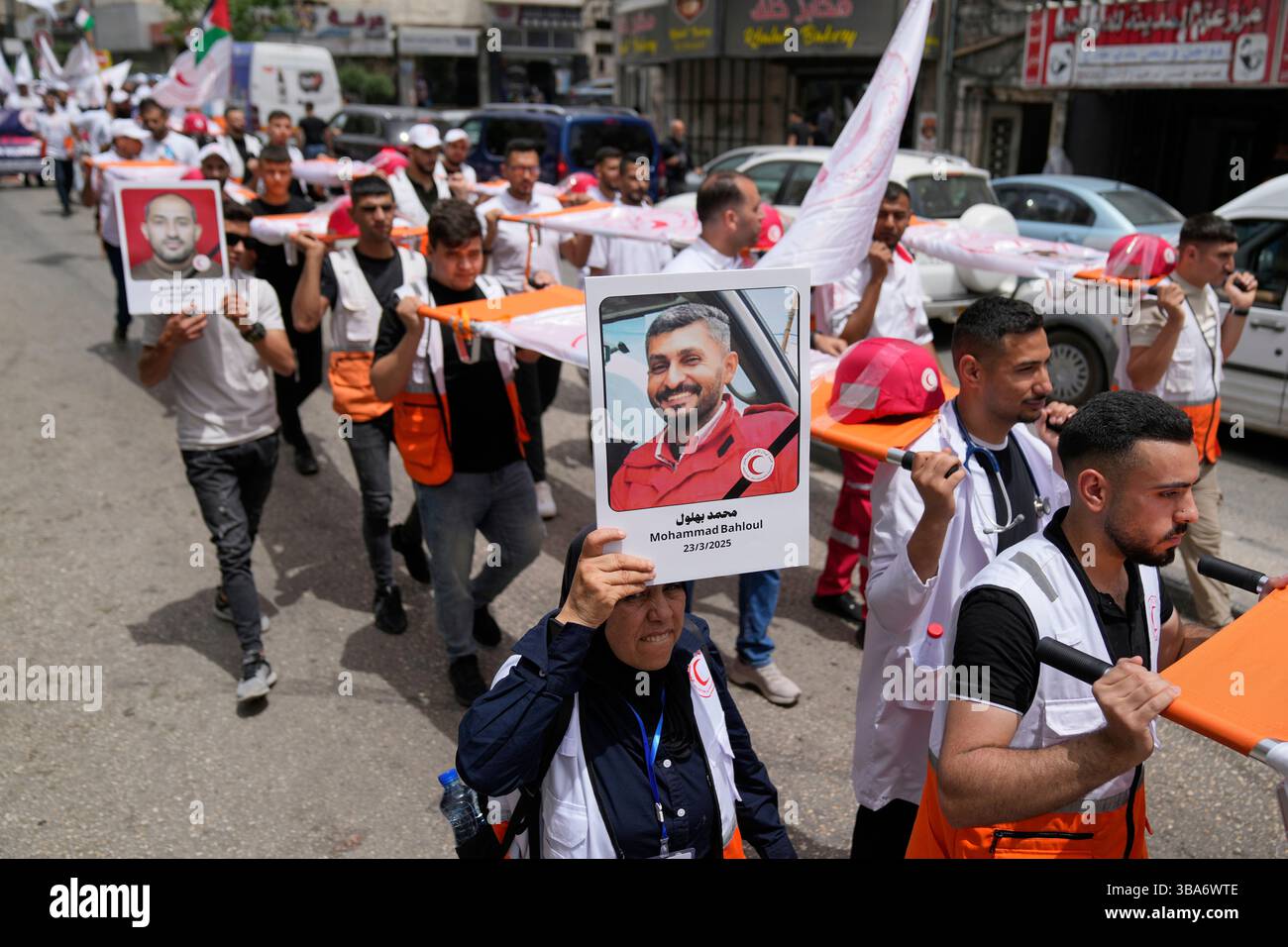 A paramedic holds posters with names and pictures of fellow relief ...