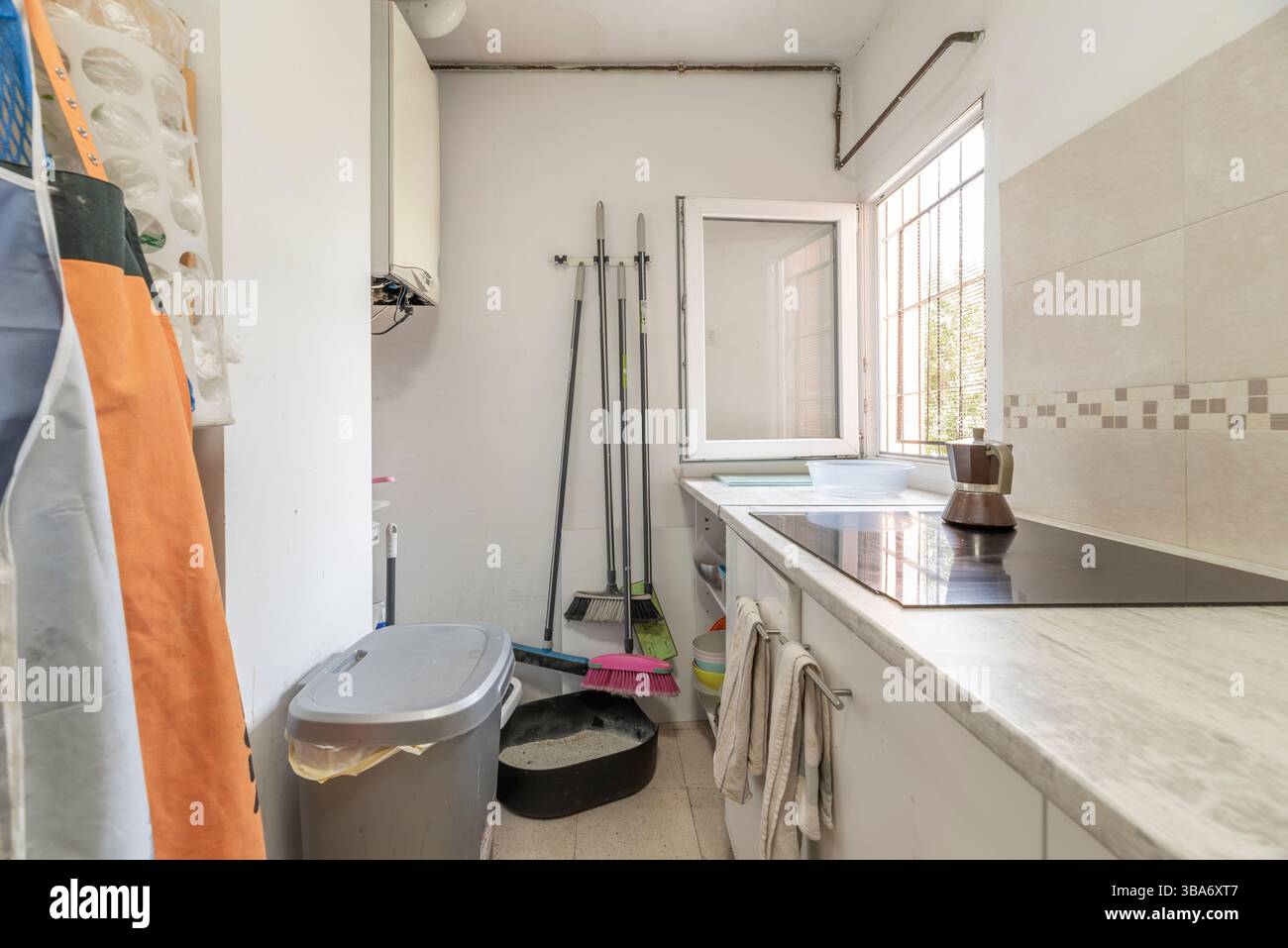 Corner of a kitchen with cleaning supplies hanging on the wall Stock ...
