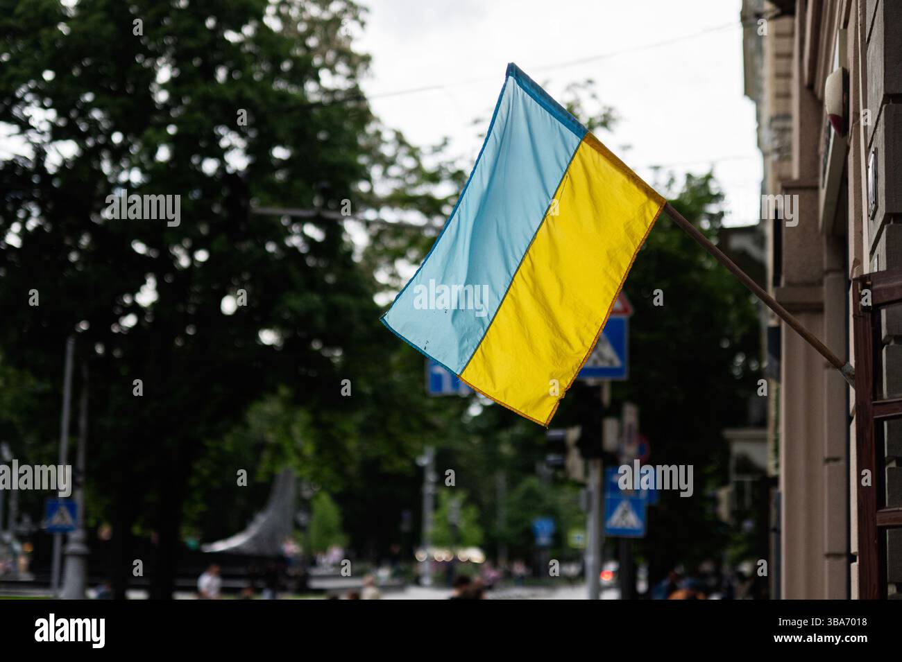 Blue and yellow Ukrainian flag flying outdoors in an urban street ...