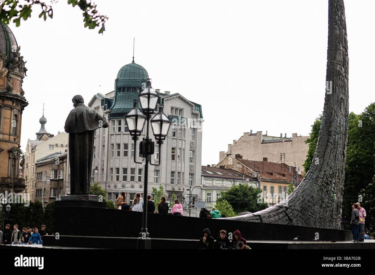 Lviv, Ukraine - May 04, 2025: Statue in a city square surrounded by ...