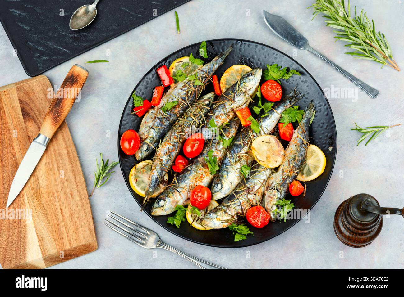 Oven baked fish sardines, with tomatoes, lemon and rosemary. Top view ...