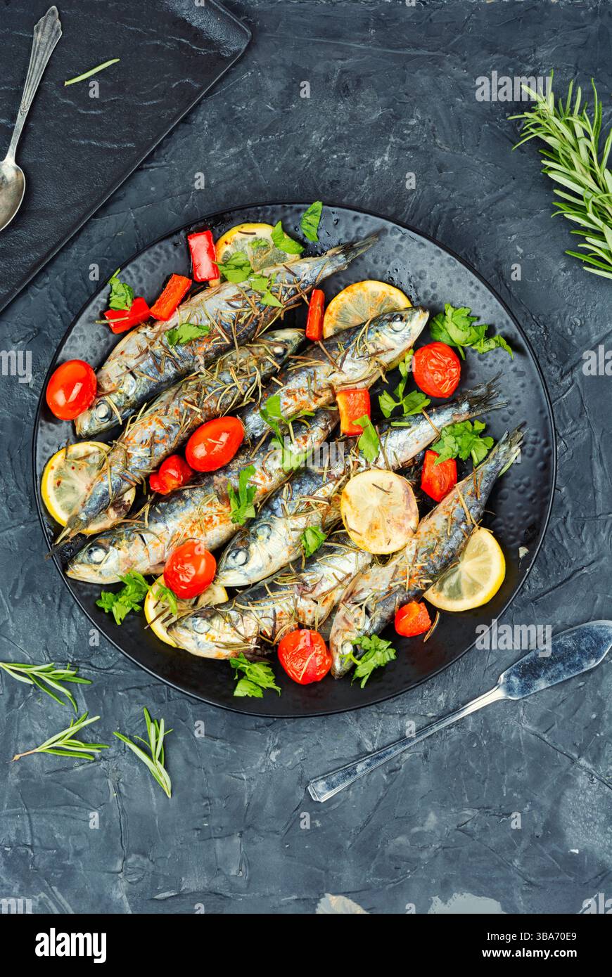Oven baked italian fish sardoncini or sardines, with tomatoes, lemon ...
