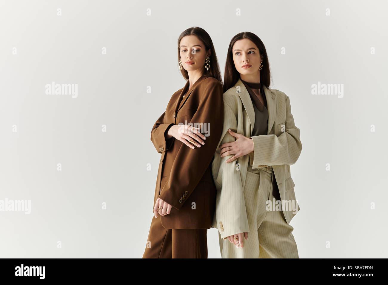 Stylish twin sisters pose gracefully, showcasing their individual ...