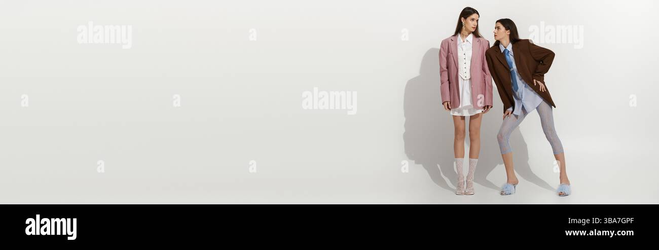 Twin sisters display their striking style while engaging playfully in a ...