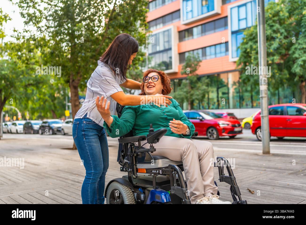 Asian caregiver hugging happily to a woman with disability sitting on ...