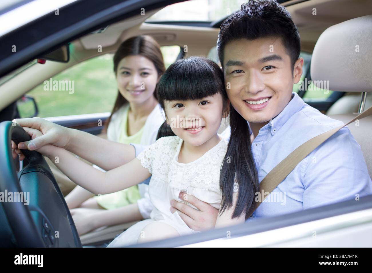 Happy young Chinese family in a car Stock Photo - Alamy