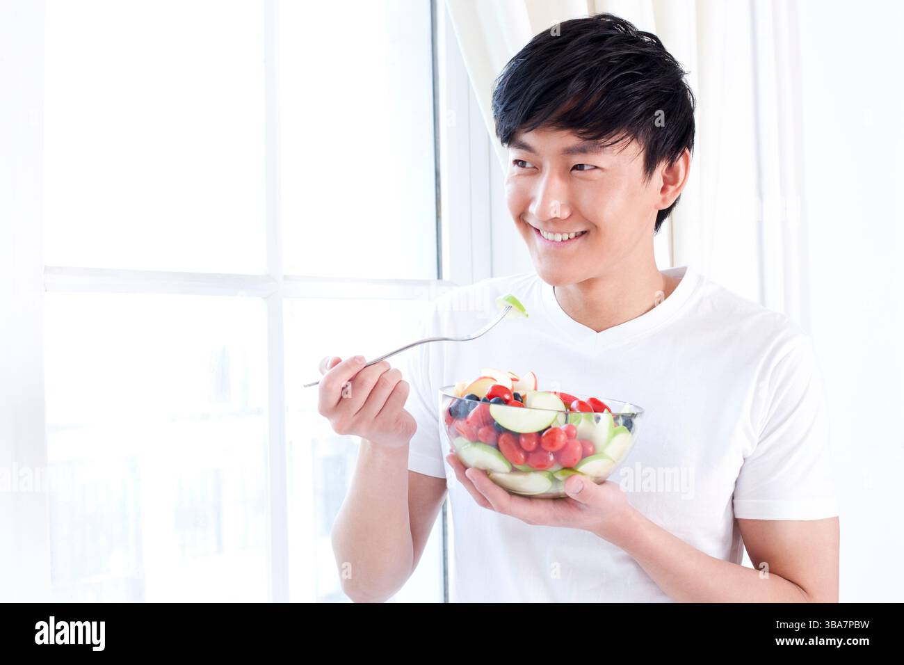 Young Chinese man eating fruit salad Stock Photo - Alamy