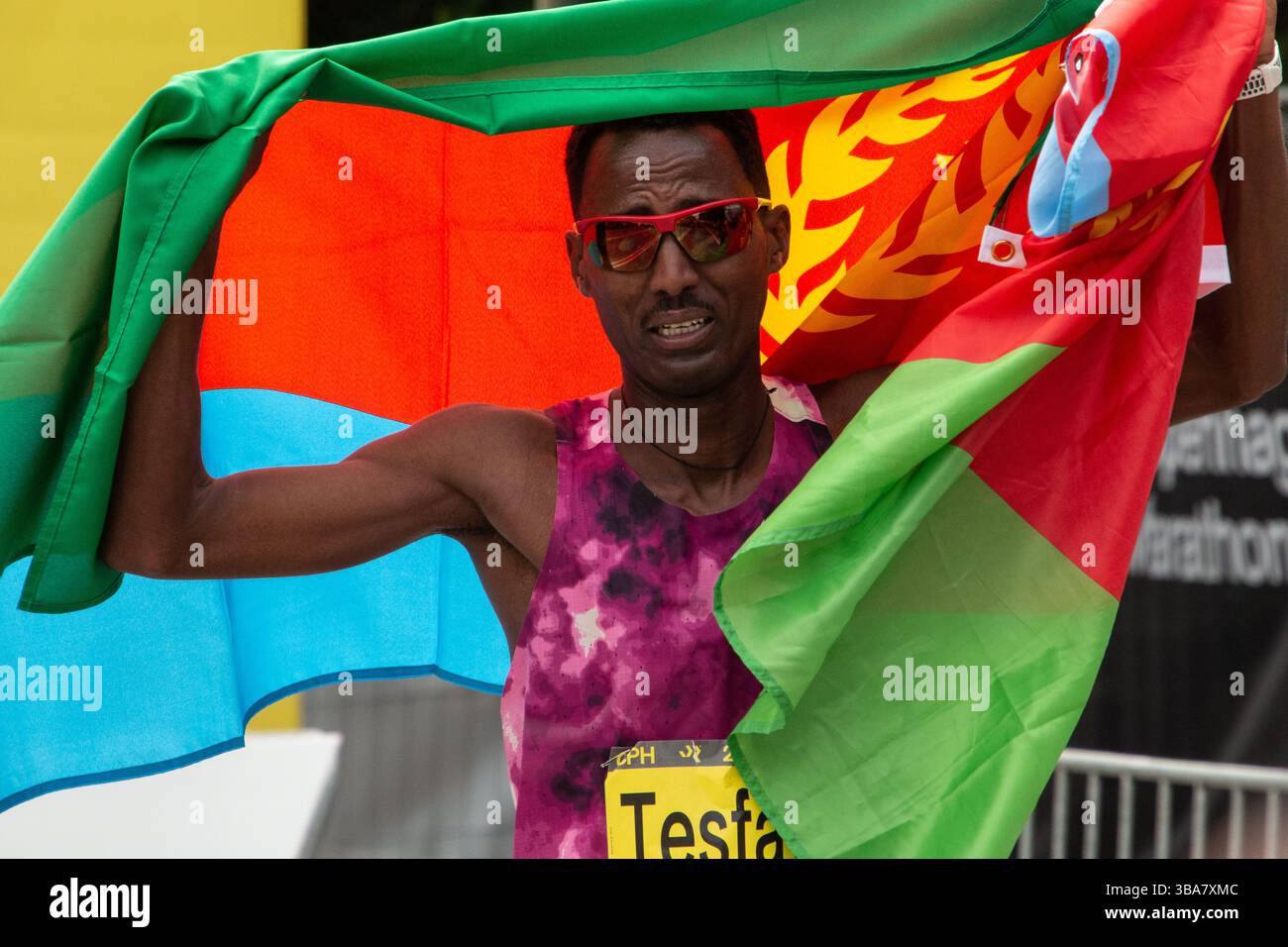 Berhane Tesfaye of Eritrea reacts after crossing the finishing line as ...
