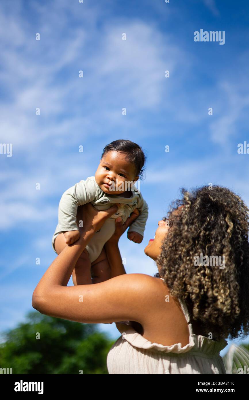 Venezuelan mother with afro hair picking up her 6 month old Venezuelan ...