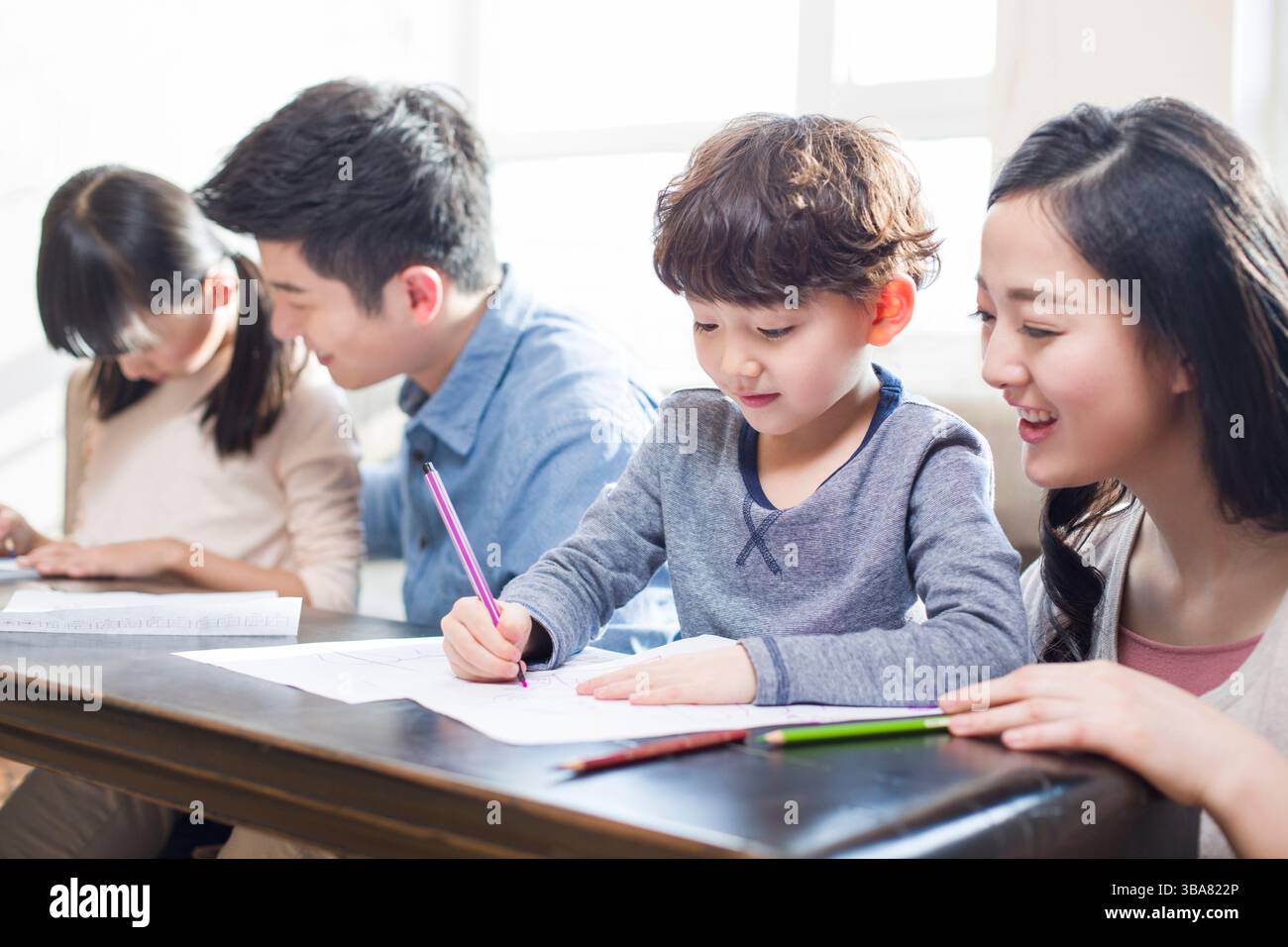 Young Chinese parents helping their children with homework Stock Photo - Alamy