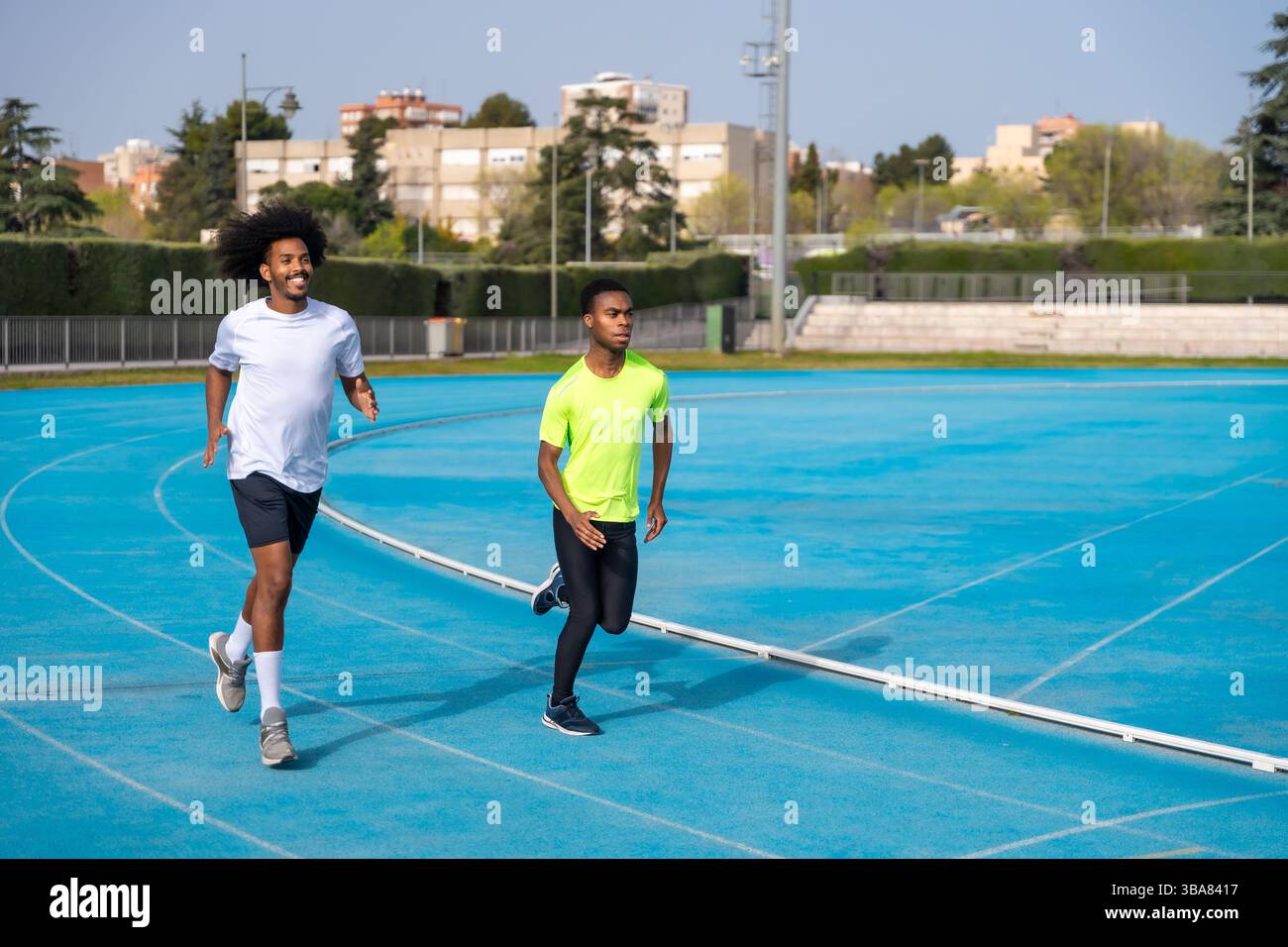 Two african american young sports men running together in an outdoor ...