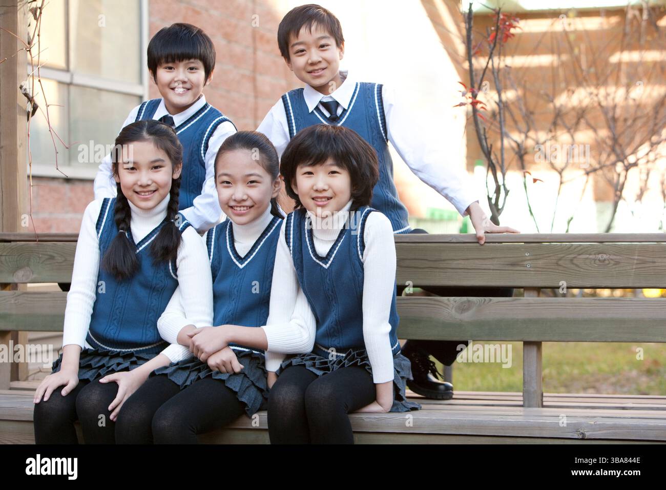 Five Chinese classmates sitting on a school bench Stock Photo - Alamy