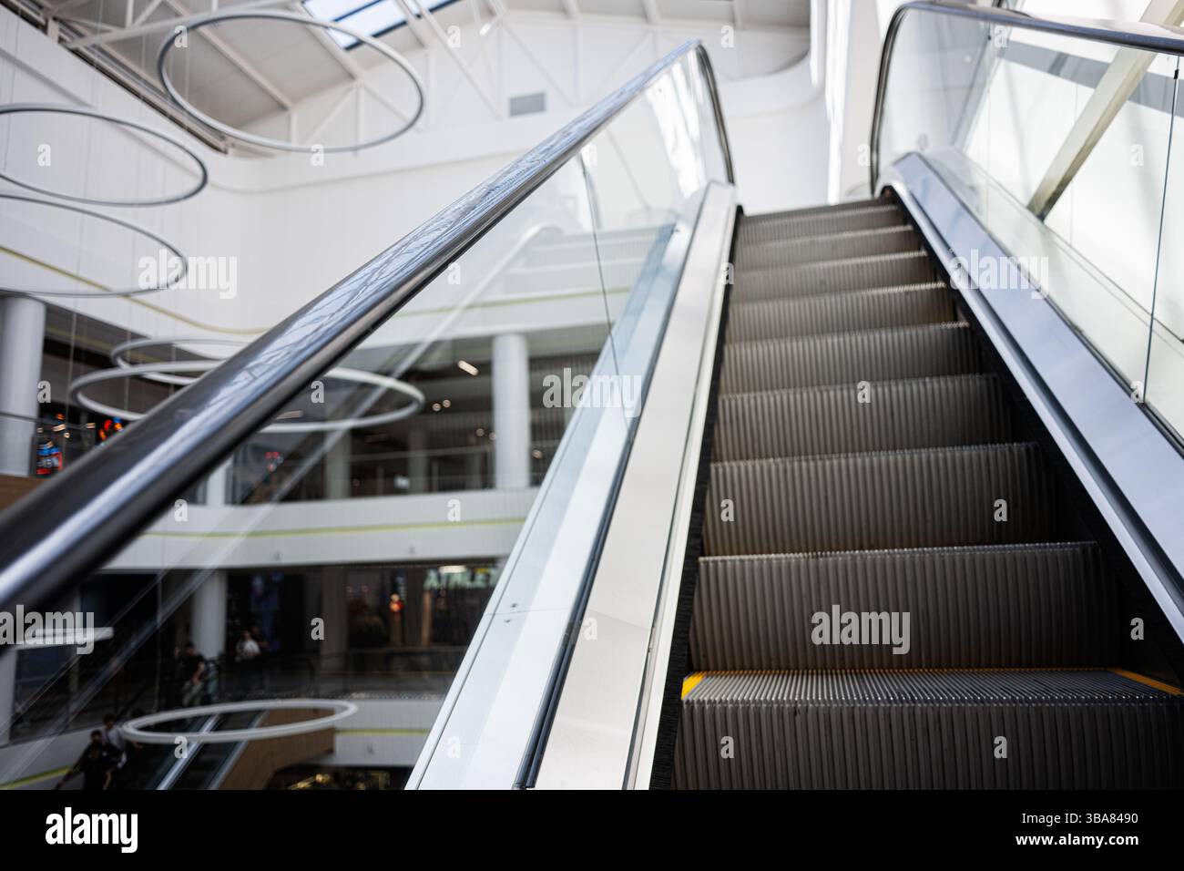 Escalator ascending in a luminous mall interior with clean and modern ...