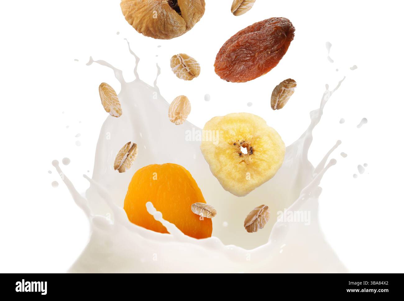 Milk splash with oat flakes and dried fruits in air on white background ...