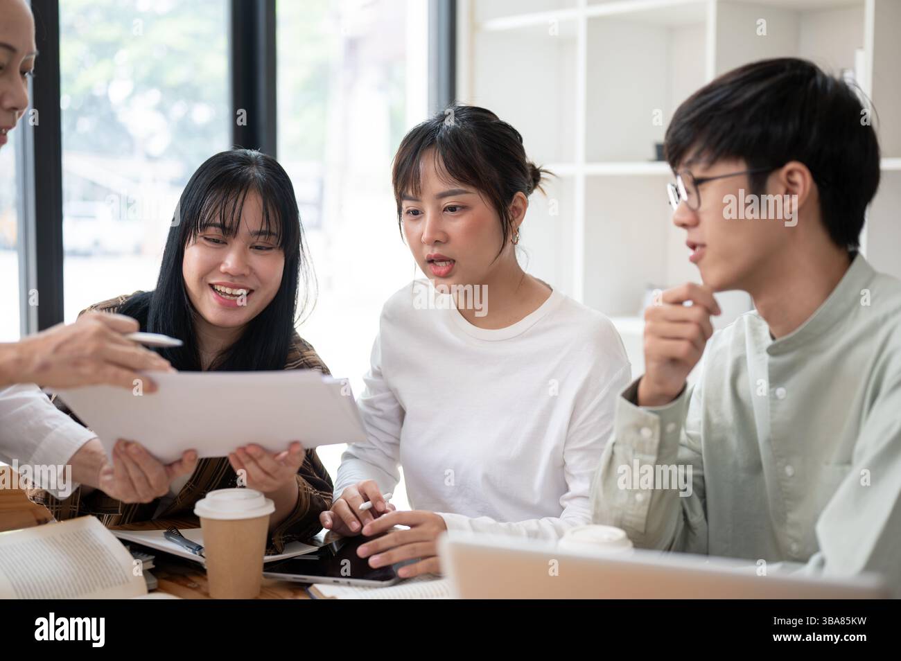 A group of young Asian university students is studying math with a ...