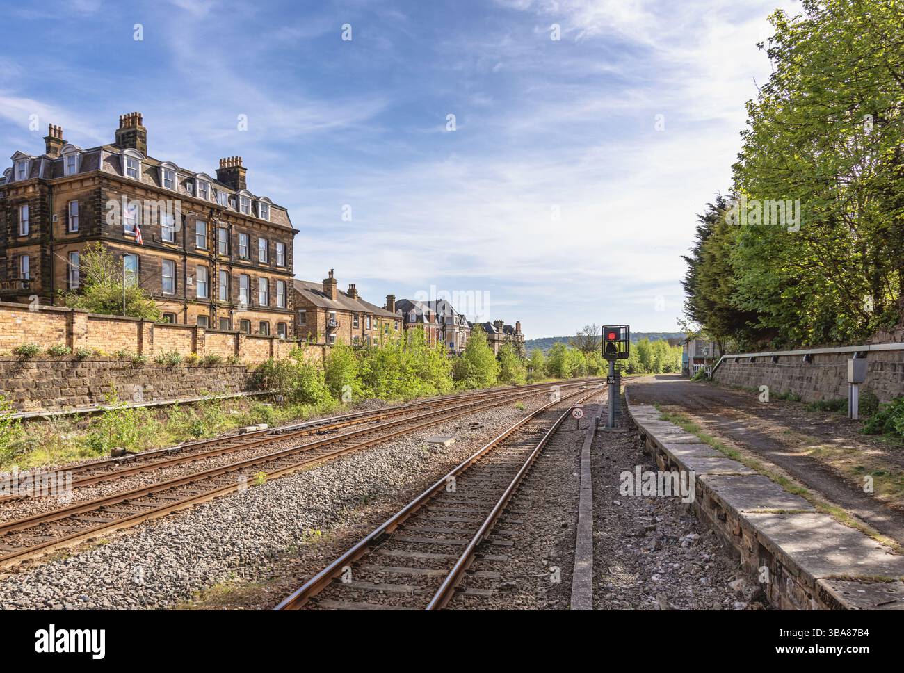 A set of railway tracks lead out from a station and curve into the ...
