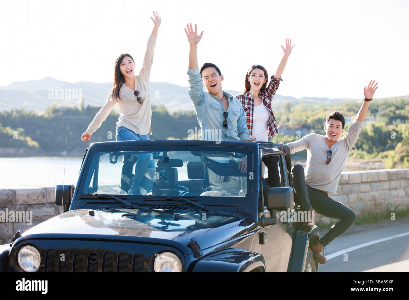 Chinese friends having fun in a jeep Stock Photo - Alamy