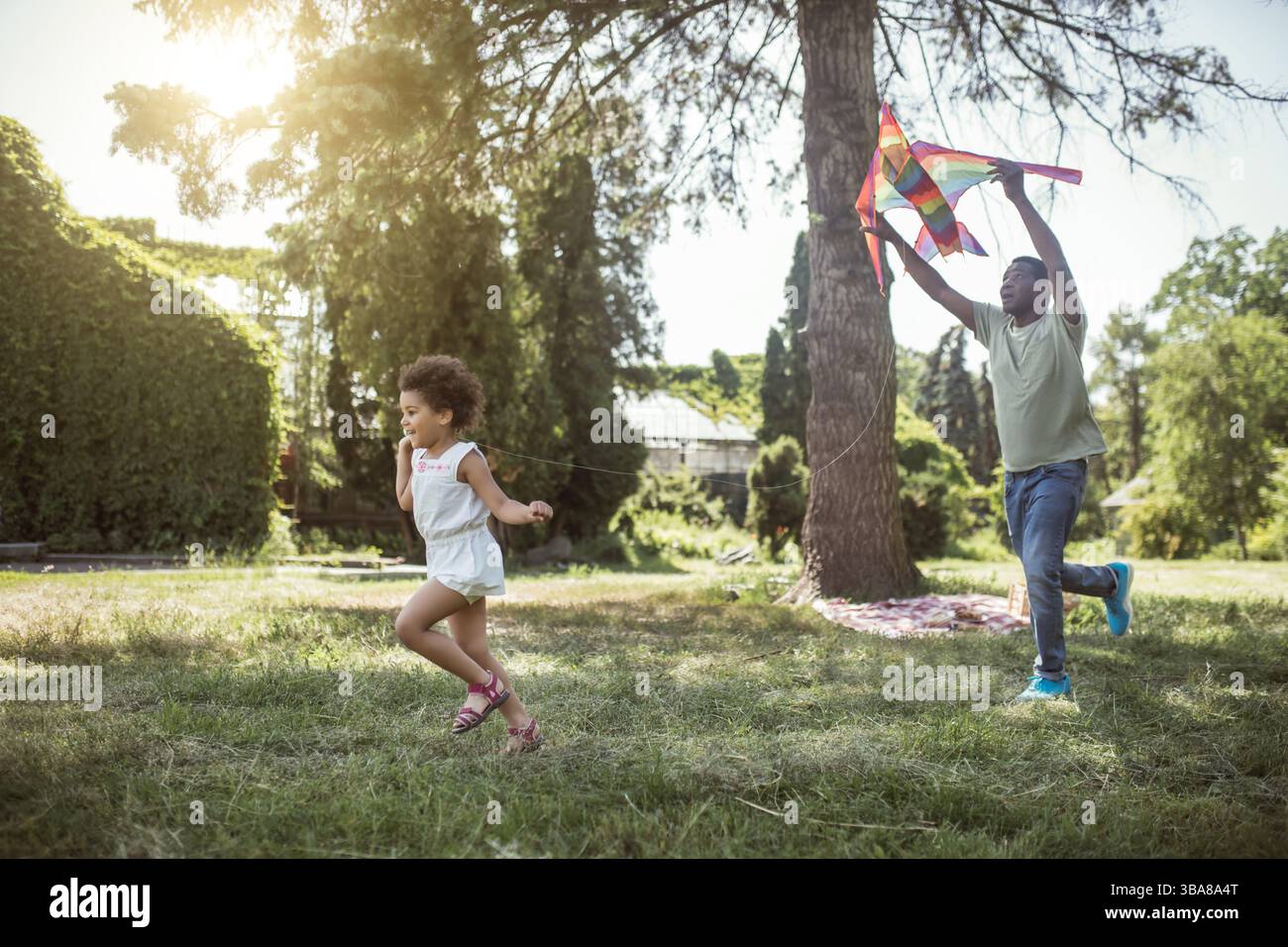 Kite. Dark-skinned man showing to his kid how to play with the kite ...