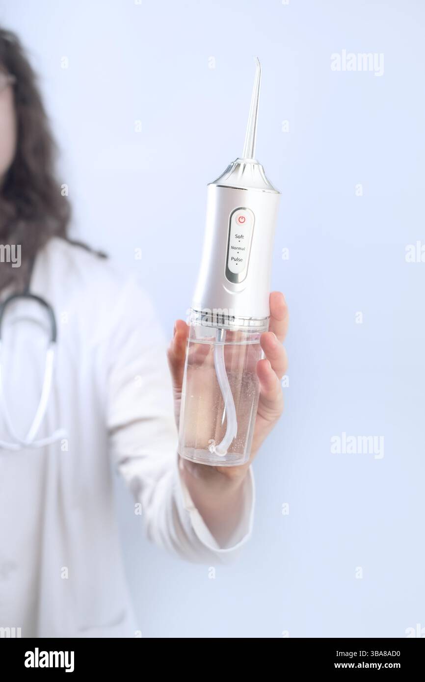 Female dentist explains how to use an oral irrigator which tips to ...