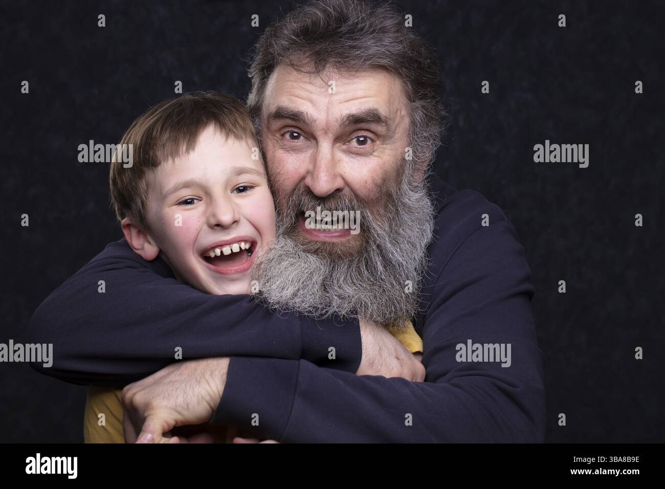 Portrait of a happy grandfather with beard and grandson on a black ...