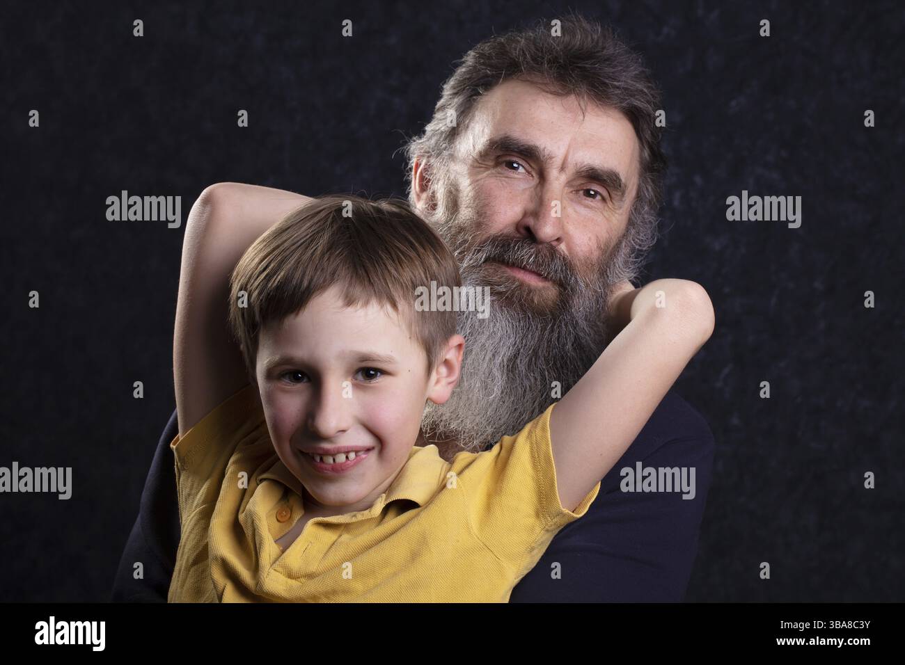 Portrait of a happy grandfather with beard and grandson on a black ...