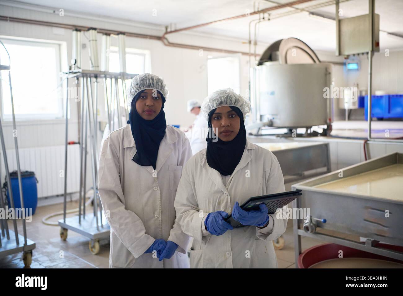 Serious Middle Eastern female factory workers in hijab and white ...