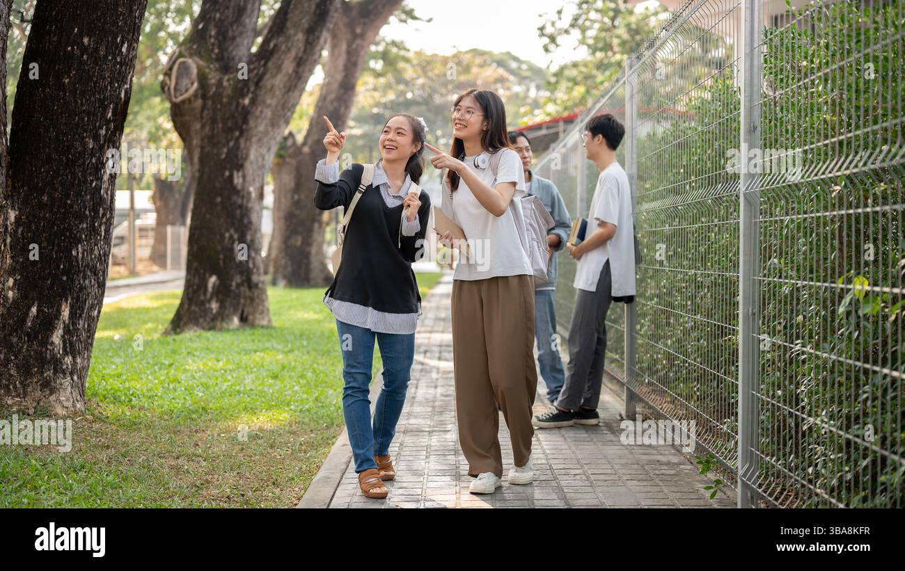 Two young Asian male students best friends are laughing and enjoying ...
