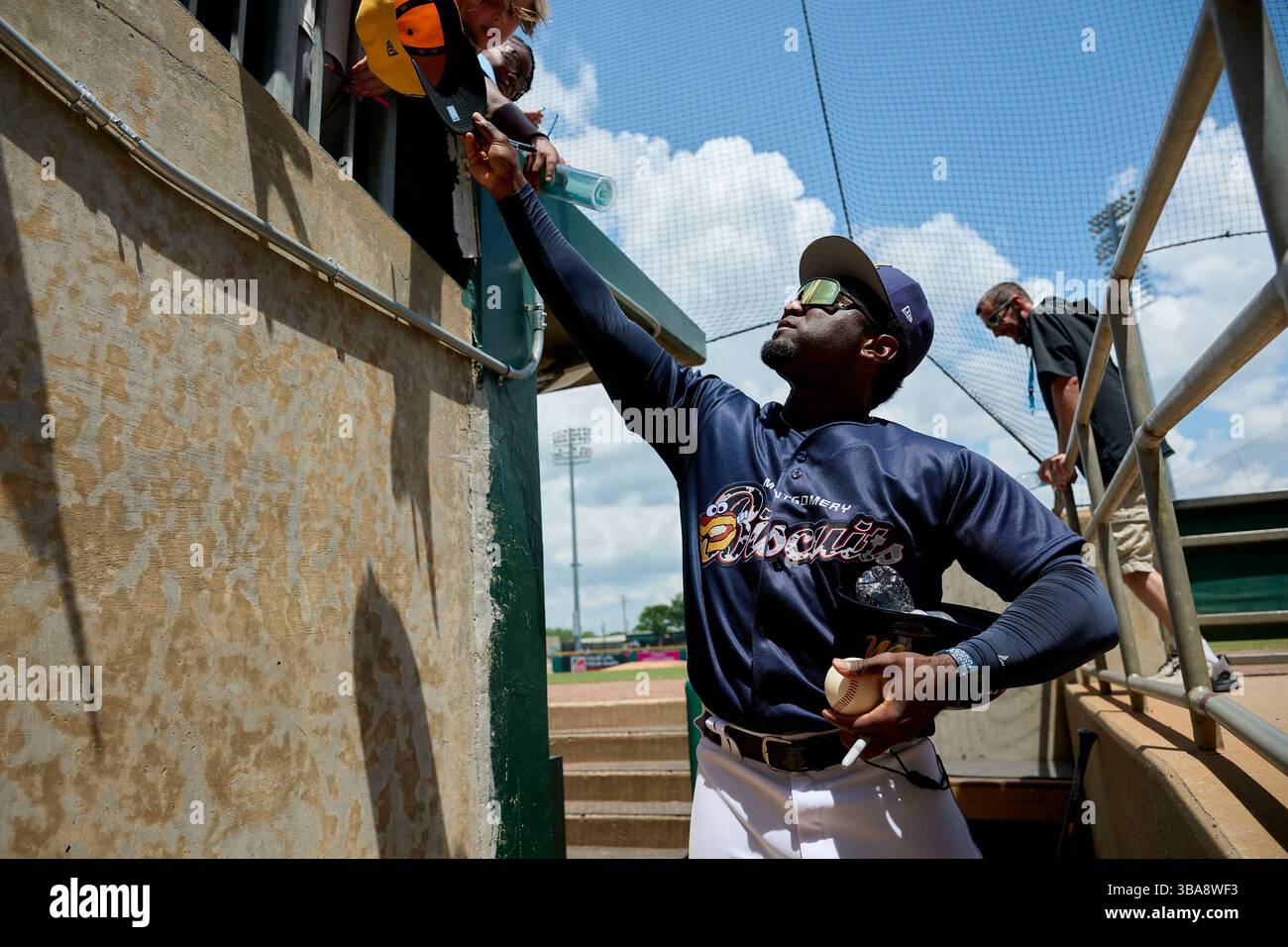 Montgomery Biscuits coach Ronnie Richardson (2) sings autographs after ...