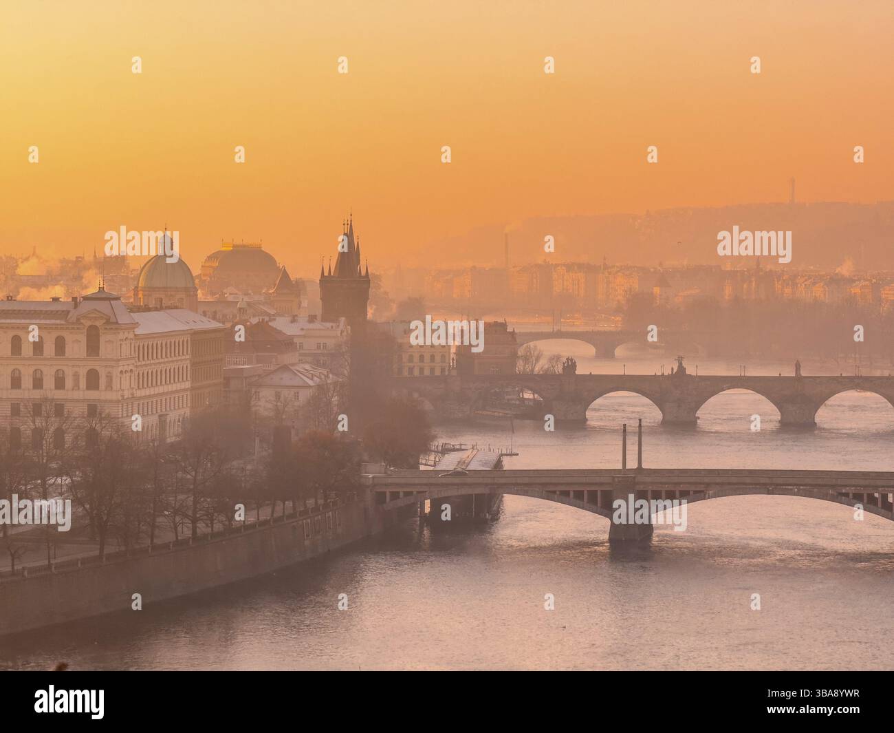 Winter frosty dawn over Prague. Picturesque golden glow and winter haze ...