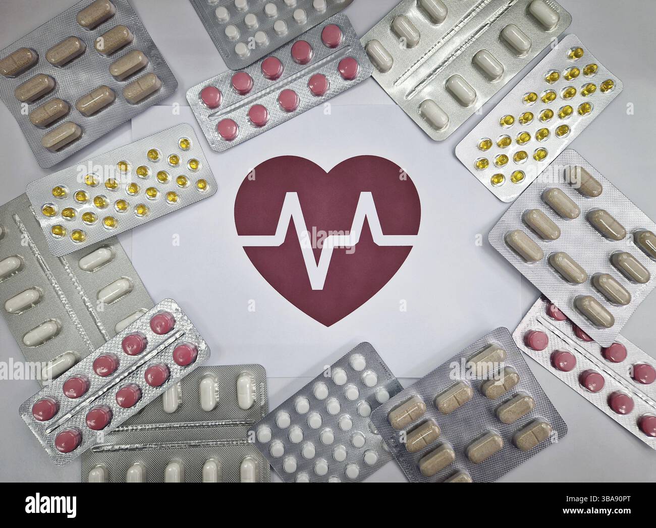 Various blister packs of pills arranged around a red heart symbol with ...