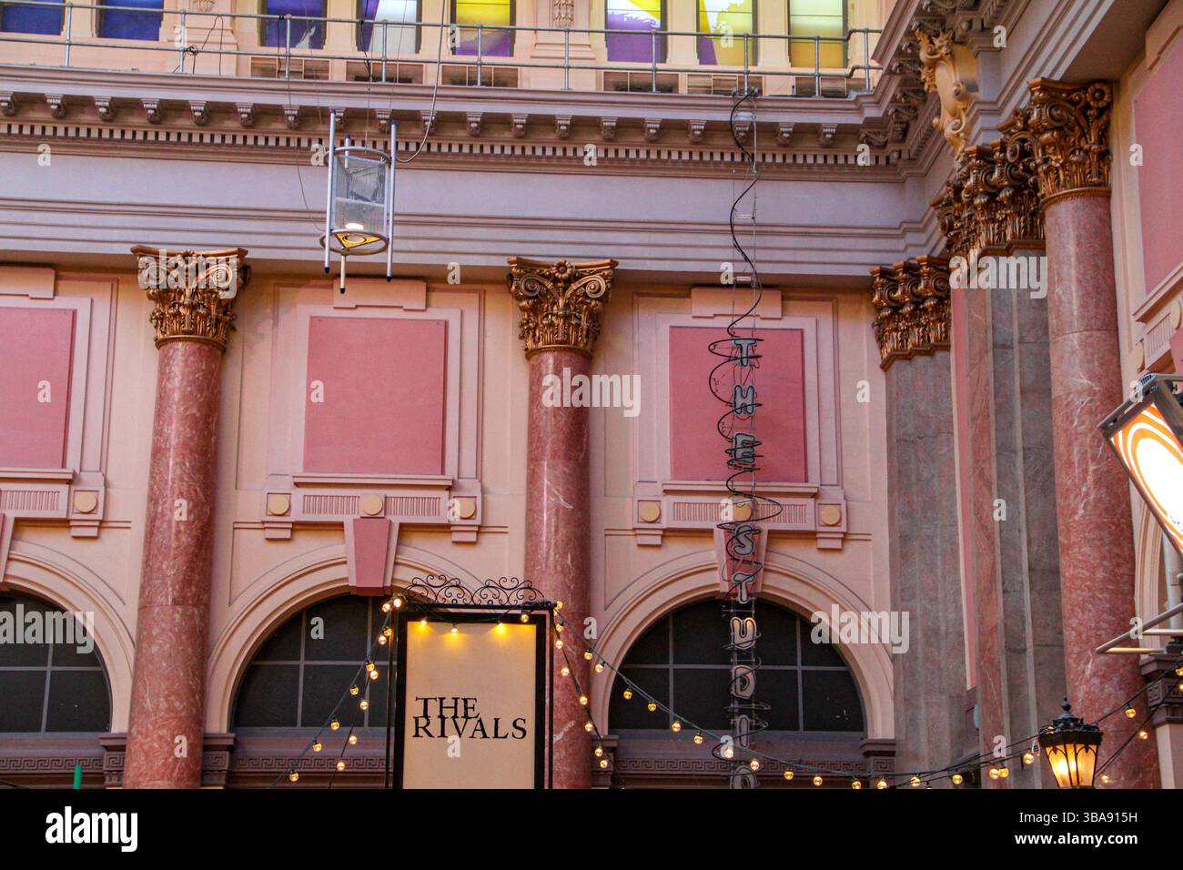 Ornate theater entrance with pink columns and golden detailing, glowing ...