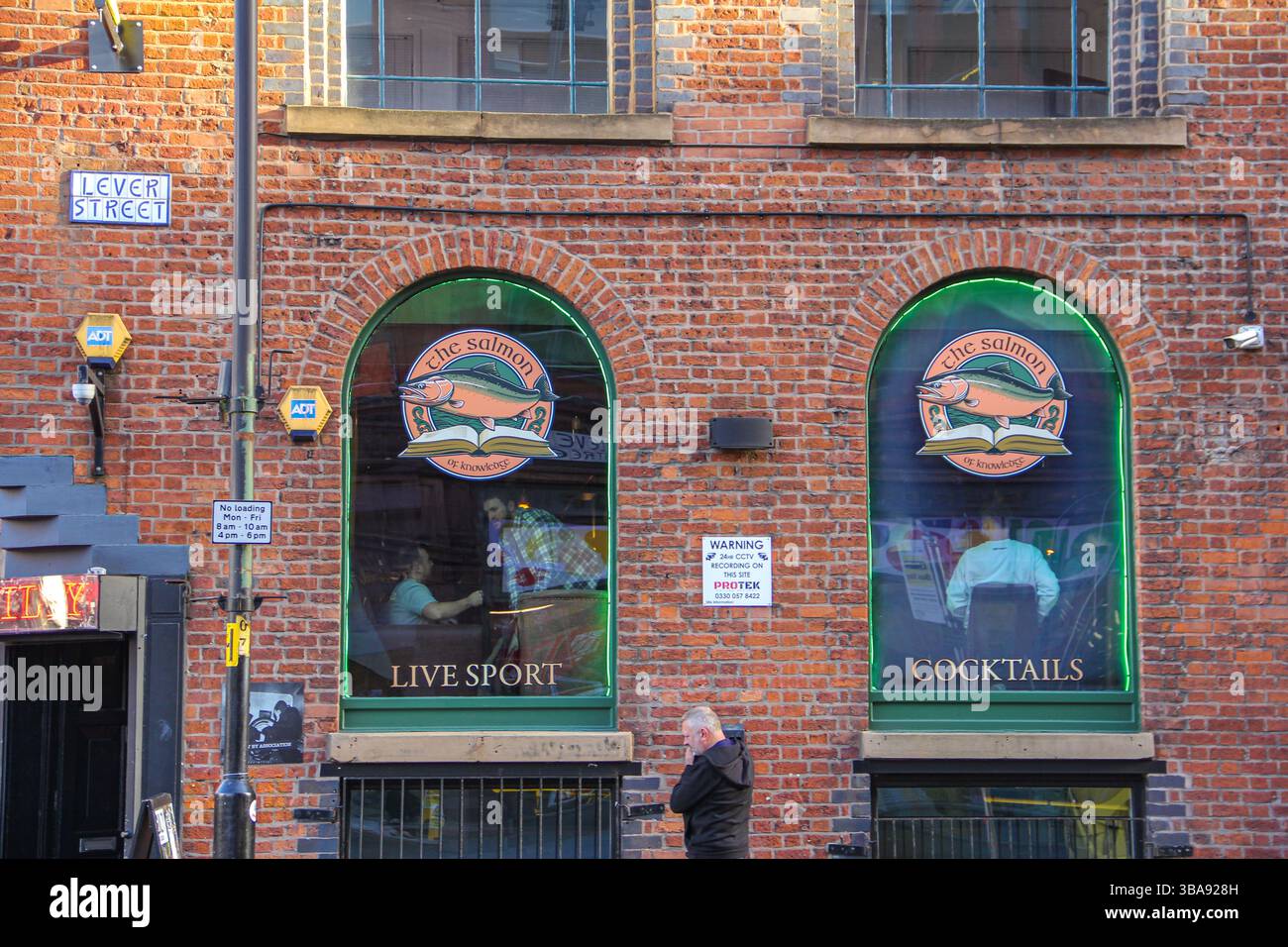A red-brick mural wall featuring painted faces, part of Manchester's ...