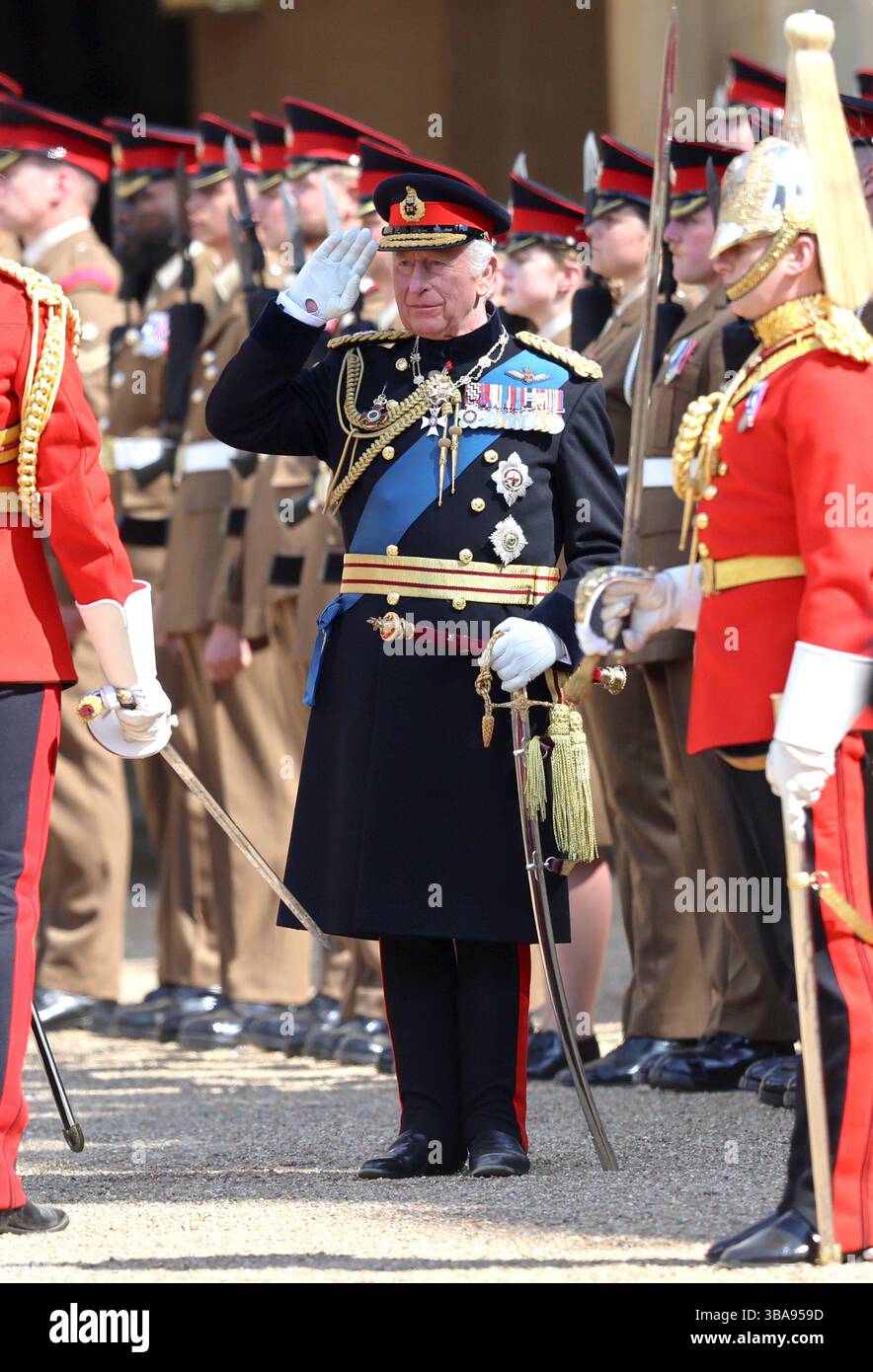 King Charles III salutes military personnel during the presentation of ...