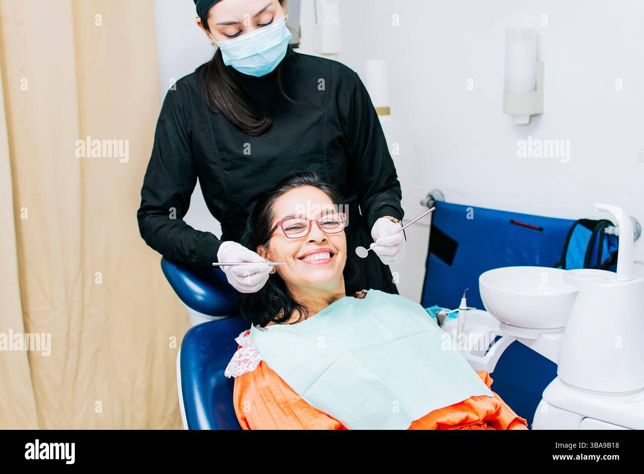 Nicaraguan female dentist wearing gloves using examination mirror and ...