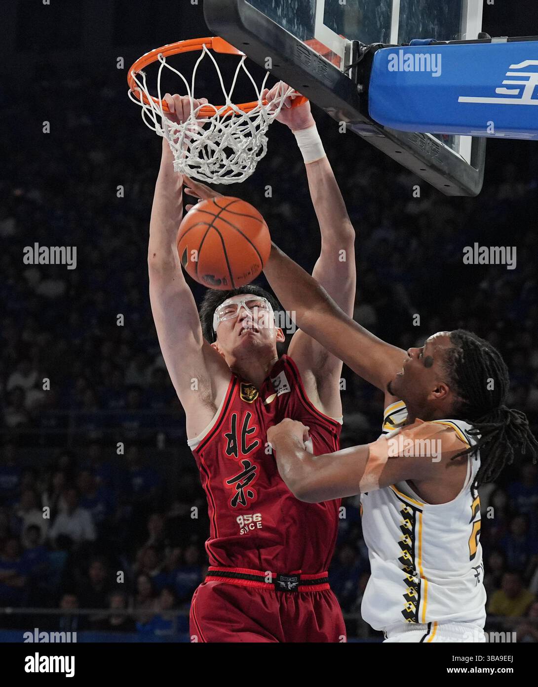 Beijing, China. 12th May, 2025. Zhou Qi (L) of Beijing Ducks dunks ...