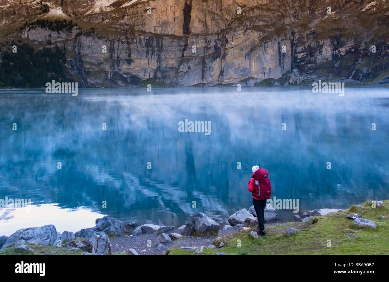 Sporty girl looking into reflection of mountains in lake. Lake ...