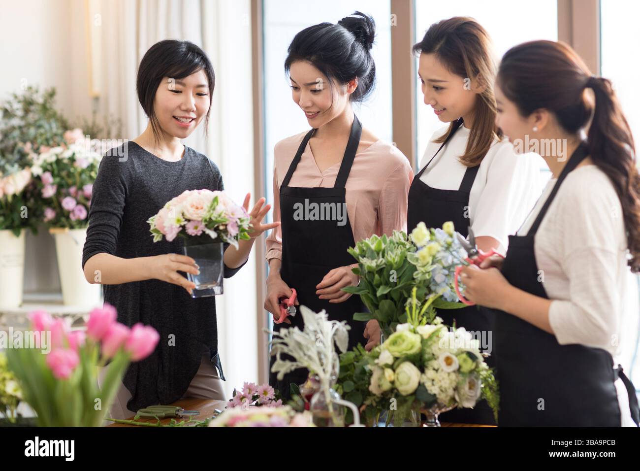 Chinese female teacher teaching women how to arrange flowers in ...