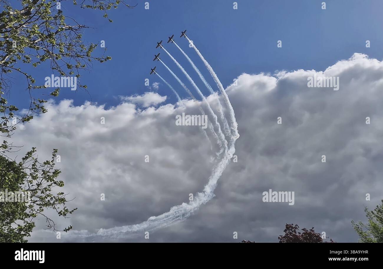 Air show with five airplanes flying in formation with white smoke ...