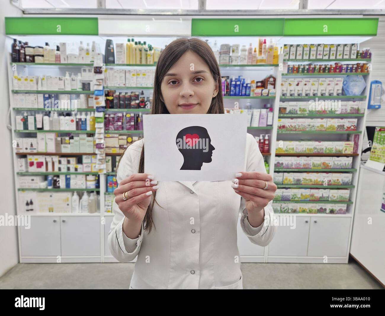 Female pharmacist holding a paper with a head silhouette featuring a ...