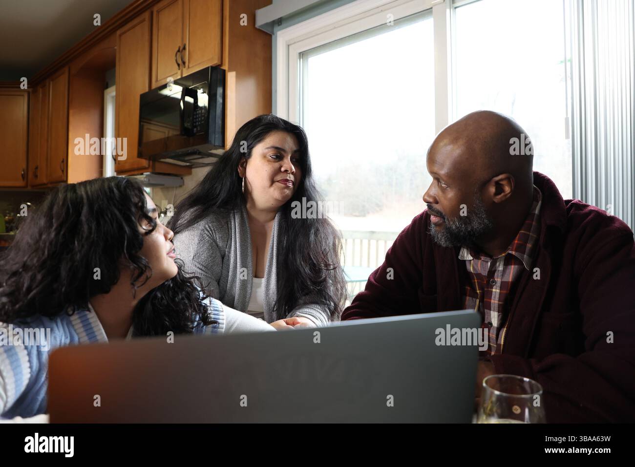 Mixed race wife and Black husband staring at each other with their teen ...