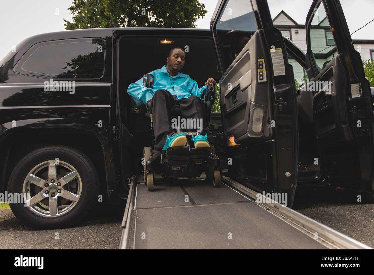 African American man with disability sitting in motorized wheelchair ...