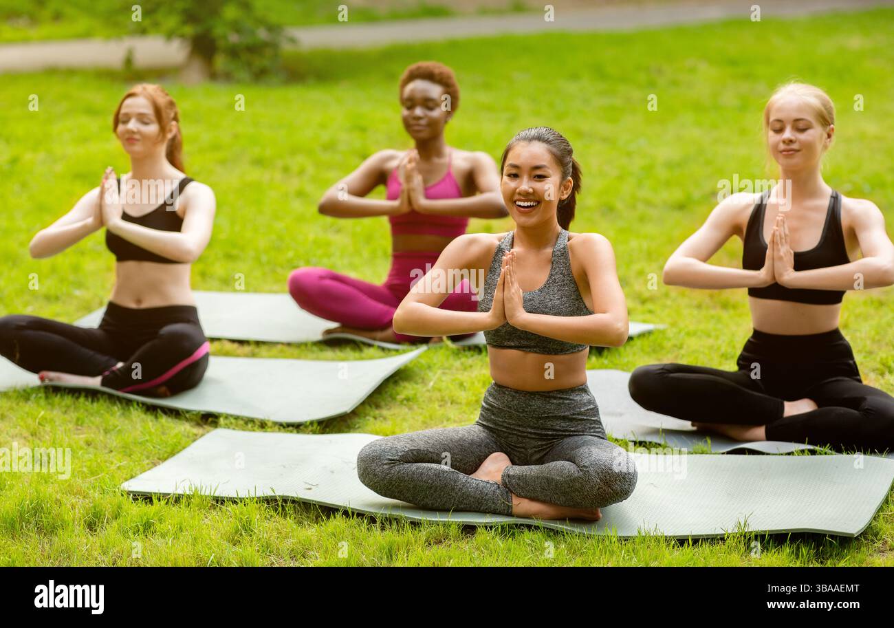 Yoga for peace and harmony. Fit young girls doing meditation or ...