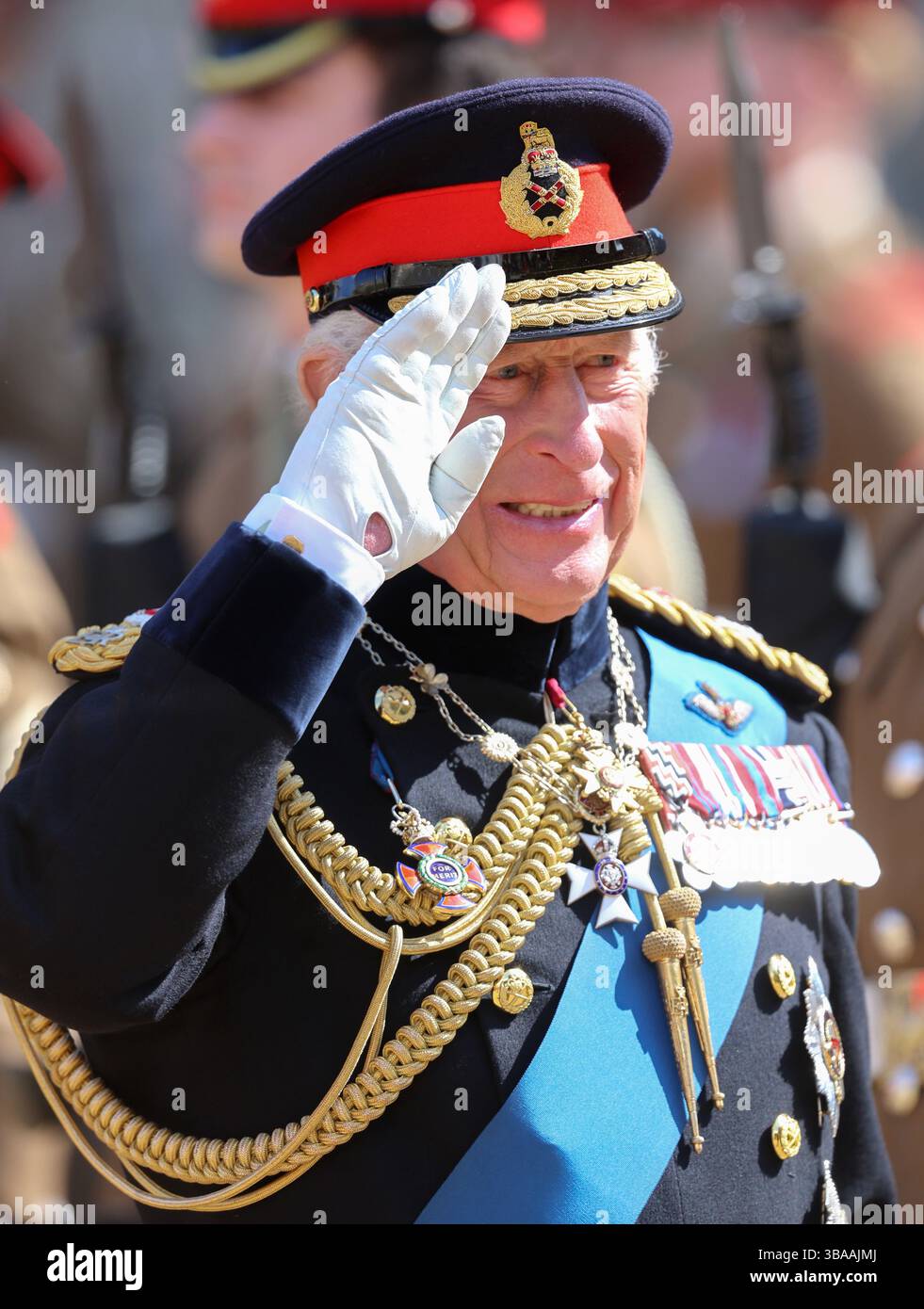 King Charles III salutes military personnel during the presentation of ...