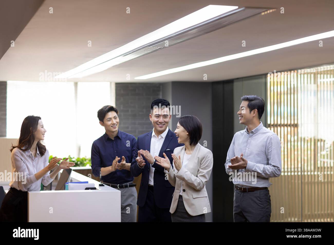 Chinese business people clapping hands standing in office Stock Photo ...