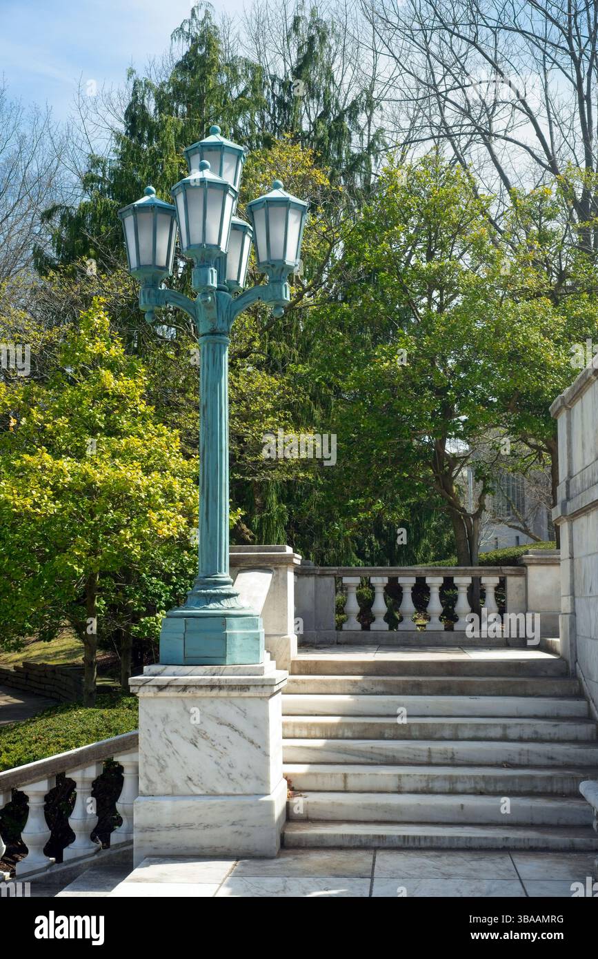 A five-lantern lamp post stands on a pedestal above steps to a public ...