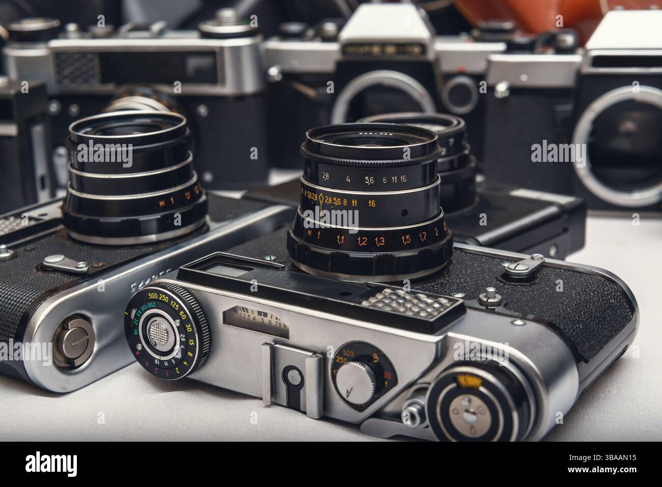 Collection of various used film cameras and leather cases illustrates ...