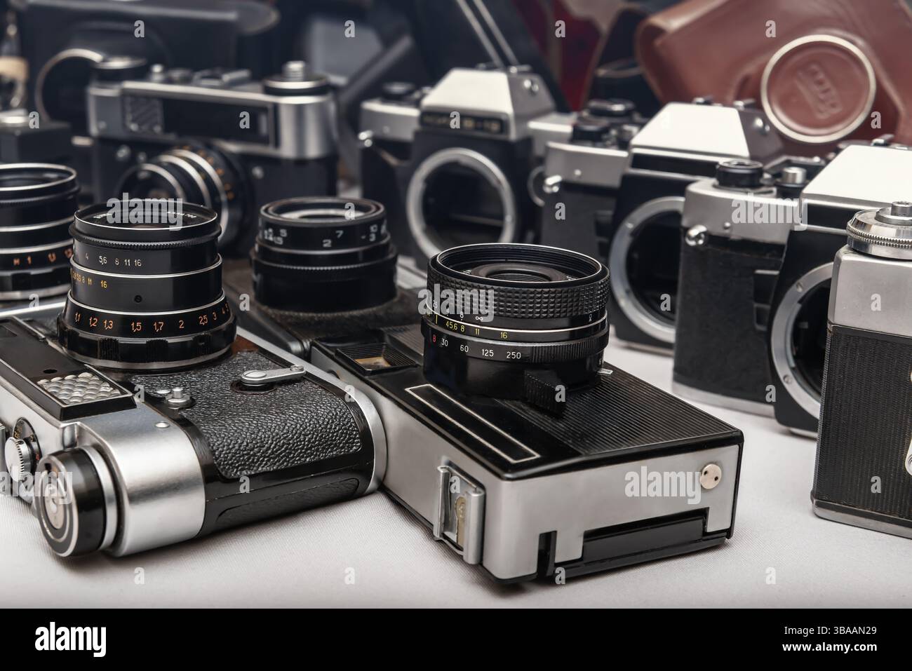 Collection of various used film cameras and leather cases illustrates ...